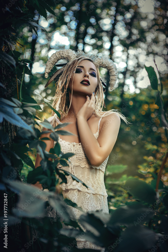 Beautiful model is posing in a forest with white horns Stock Photo ...