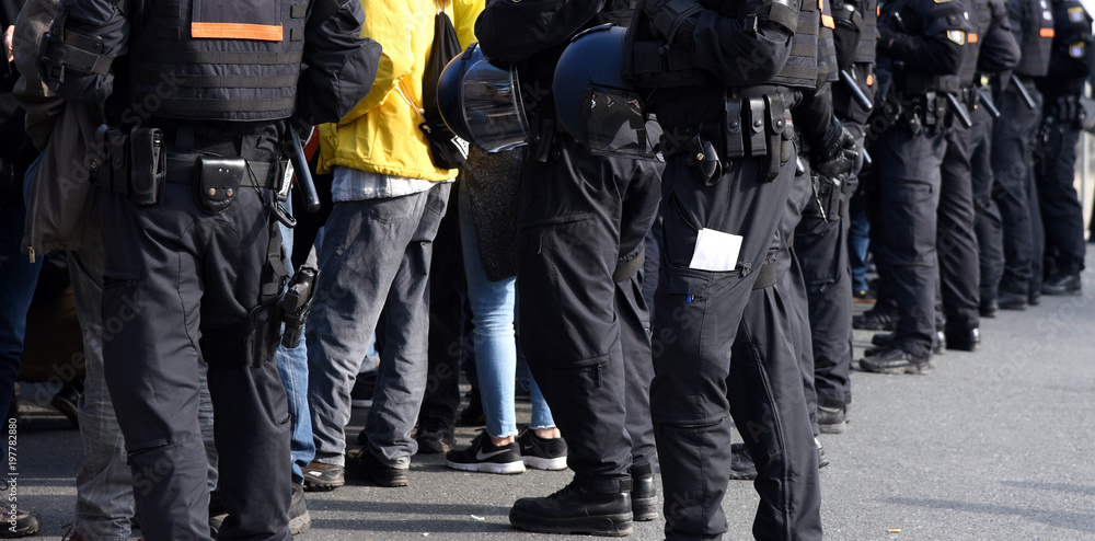 Polizisten in schwarzer Uniform und voller Ausrüstung im Einsatz auf ...