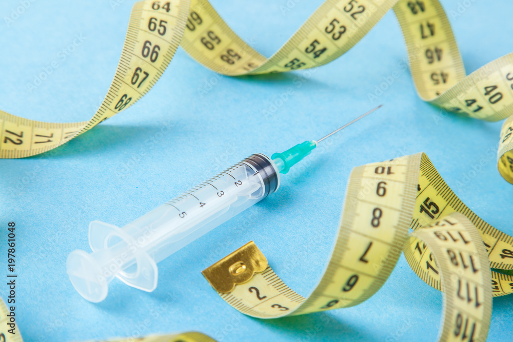 Stockfoto Syringe with a needle and yellow measuring tape. Injections ...