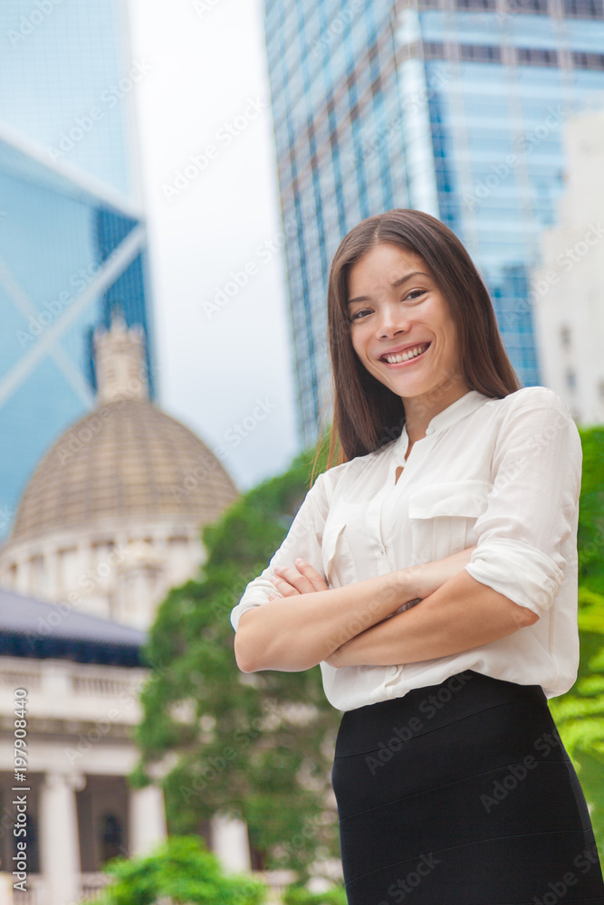 Happy confident young Asian business woman with arms crossed in urban ...