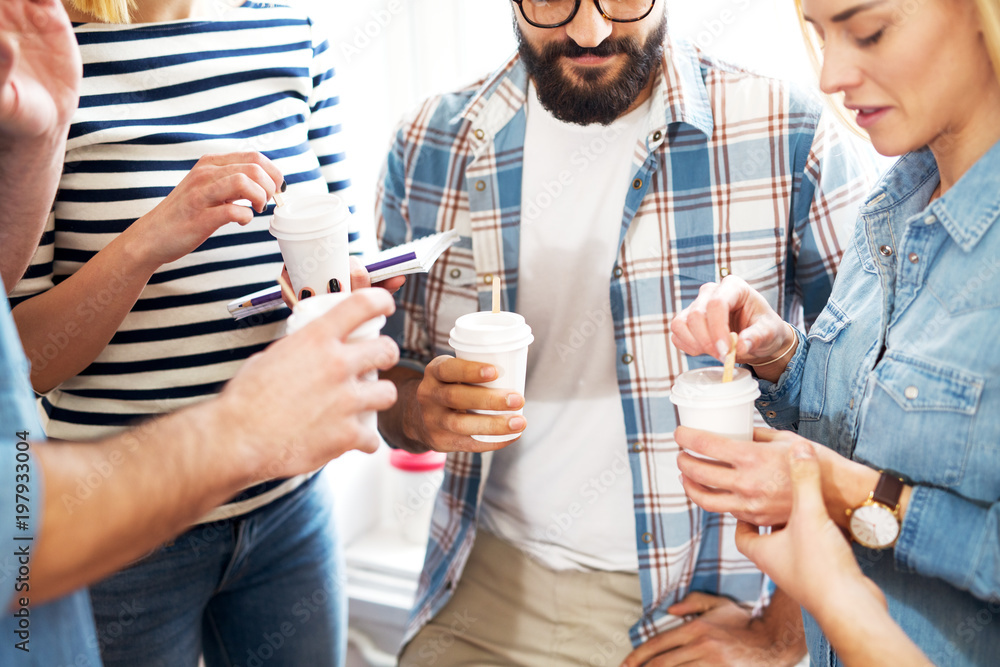 Close up view of young cheerful people having a break and drinking ...