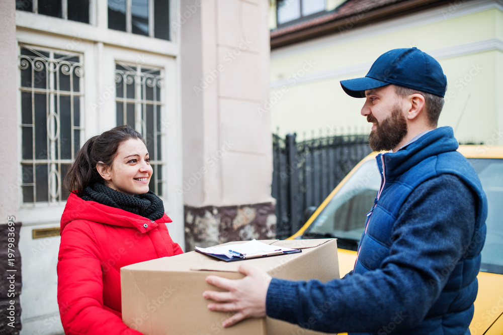 Woman receiving parcel from delivery man at the door. Stock Photo ...