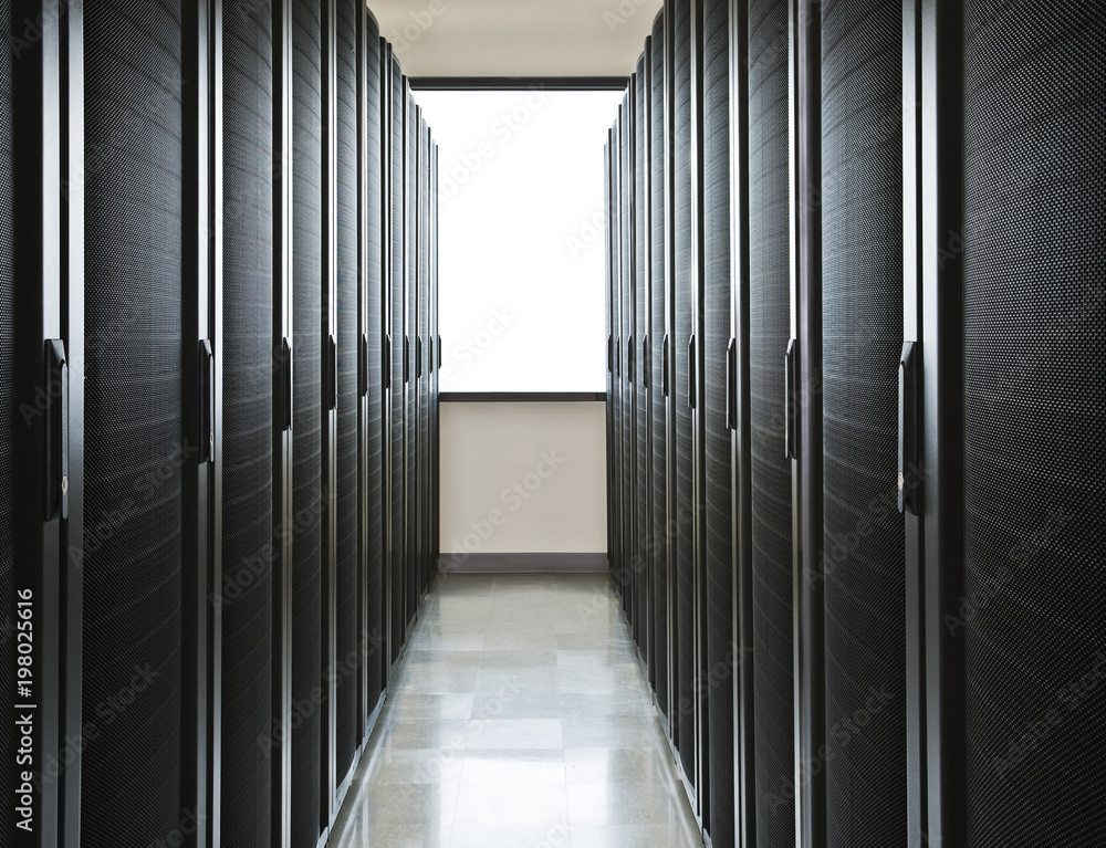 Storage racks aligned in a computer server room with a large window in ...