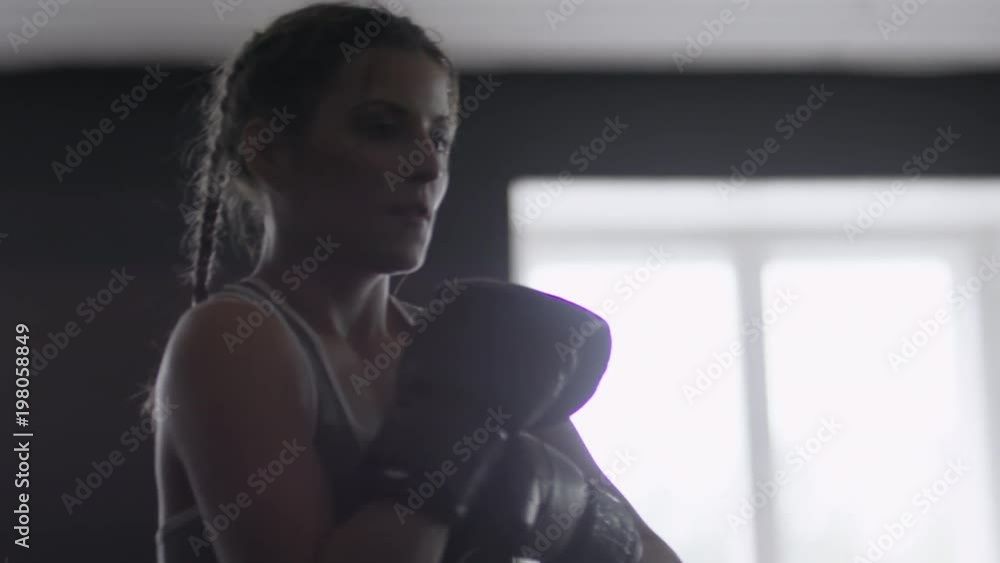 Fit young woman with braids trying her boxing gloves and then doing ...