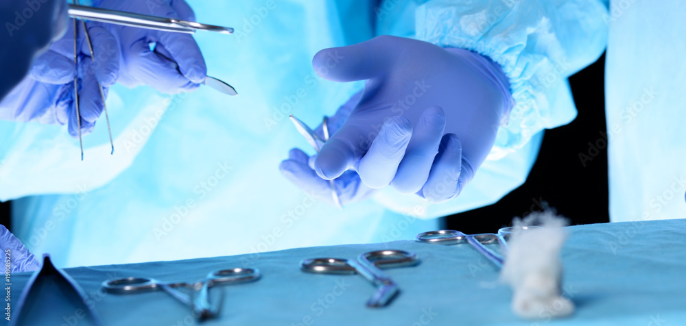 Surgeons hands holding surgical scissors and passing surgical equipment ...