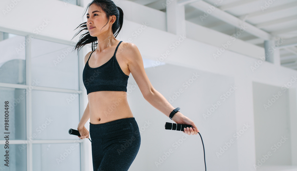 Woman doing fitness training with jump ropes Stock Photo | Adobe Stock