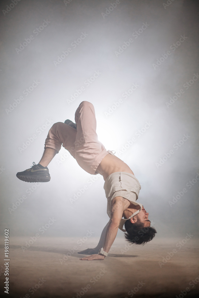 young Asian man with black hair is doing back flip full twist on the ...