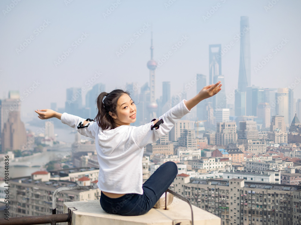 Beautiful young brunette woman sit on top of mansion roof with blur ...