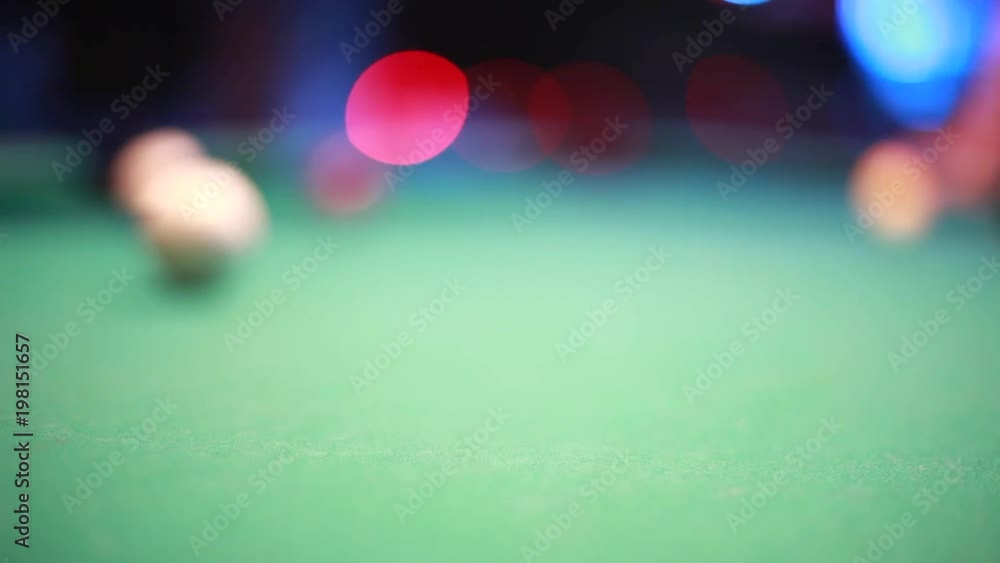 Playing pool billiards in a night bar with bokeh lights on the ...