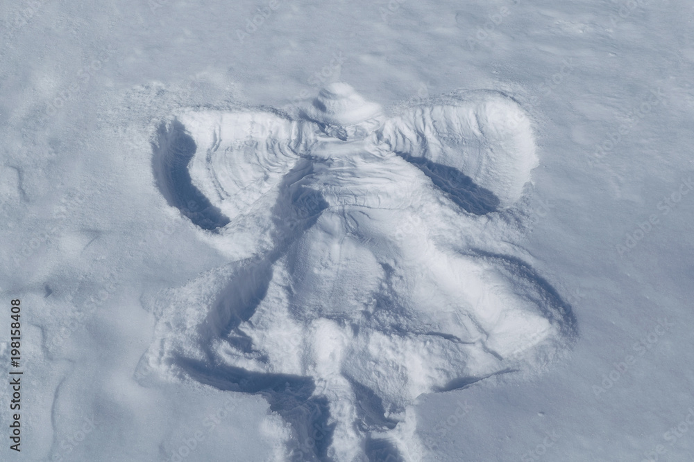 On the white snow the imprint of a child in the form of an angel ...