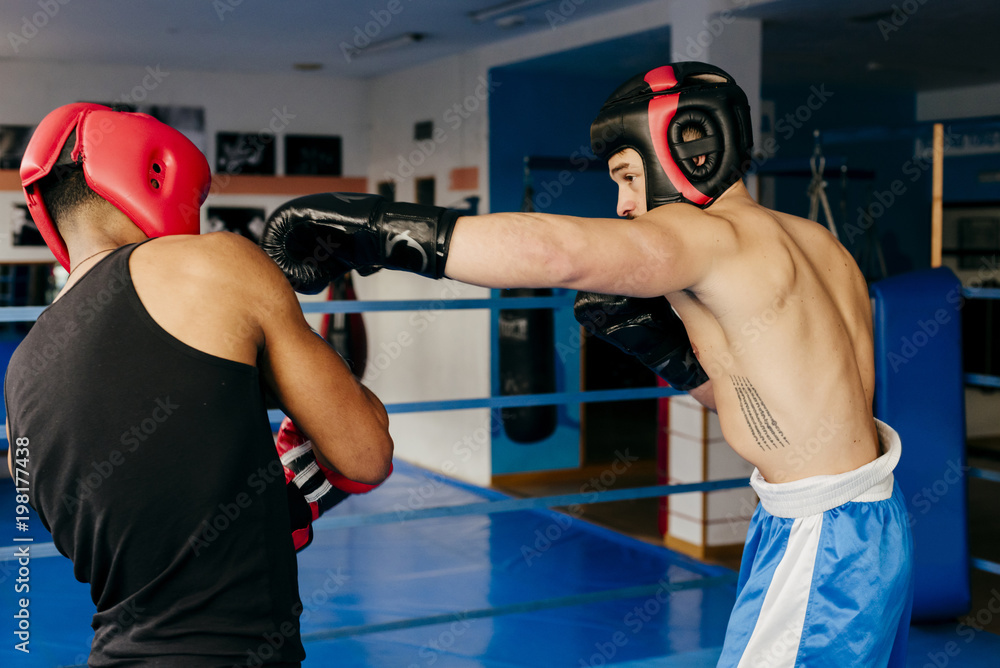 Men in helmets fighting boxing in the gym Stock Photo | Adobe Stock