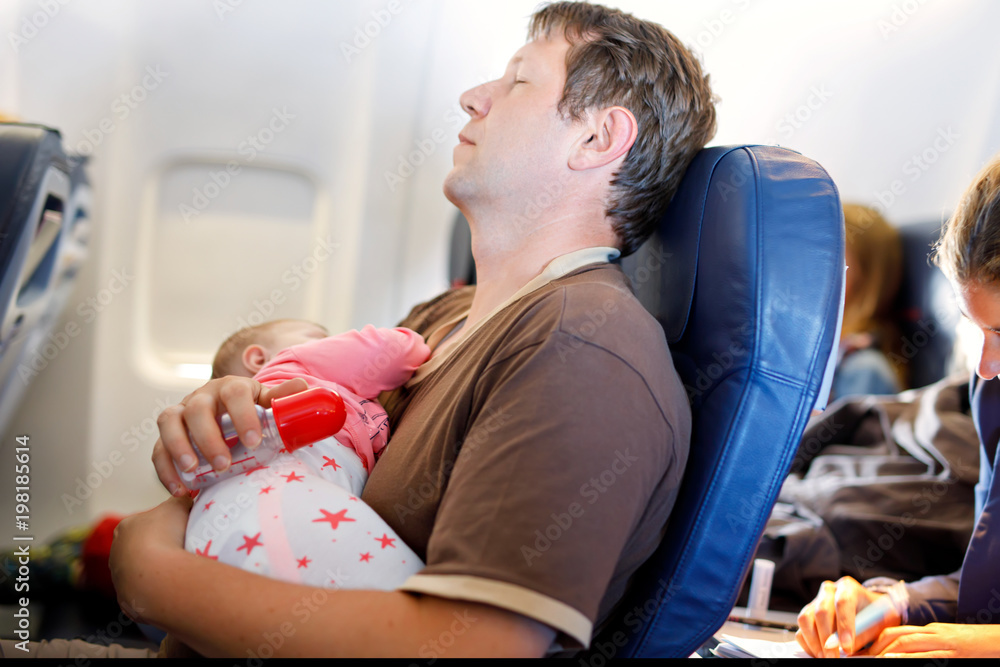 Young tired father and his baby daughter sleeping during flight on ...