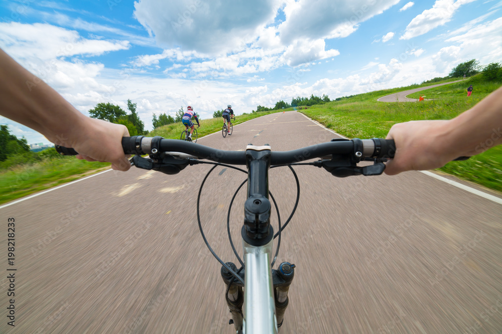 Rider driving bicycle on an asphalt road. Two hand on bike handlebar ...