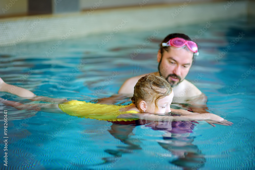 Happy father teaching his little daughter to swim. Active happy child ...