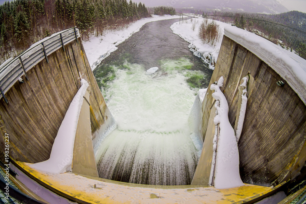 Above view of water reservoir with small dam. Small pile of snow and ...