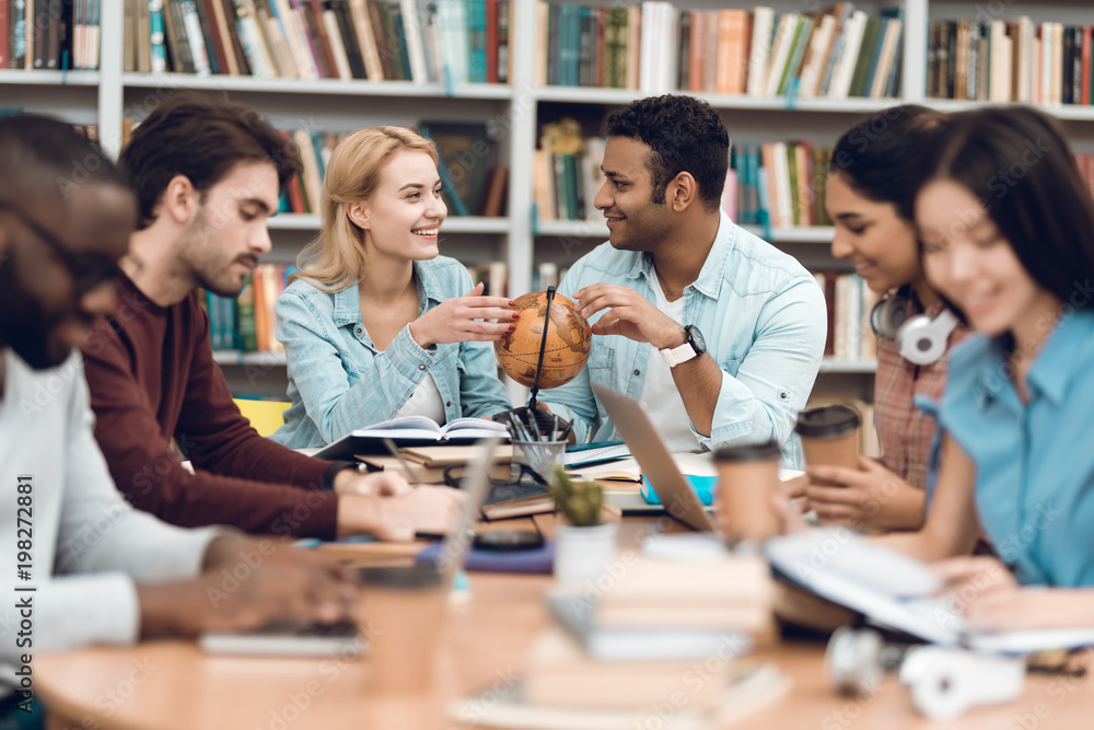 Group of ethnic multicultural students in library. Students are talking ...