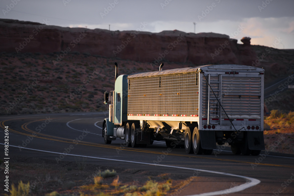 Foto de Big rig semi truck with bulk covered semi trailer going on ...