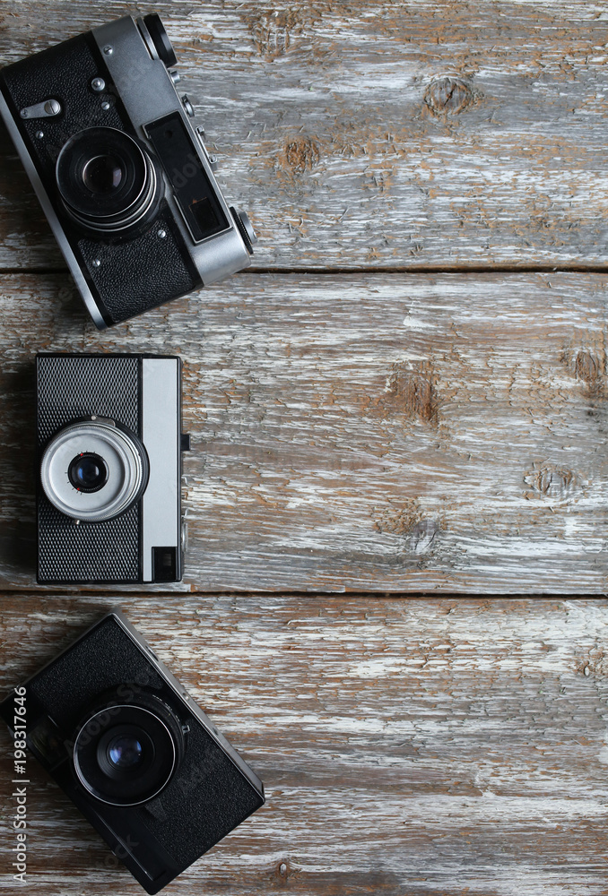 Old photo cameras on old wooden texture. Vintage film cameras on ...