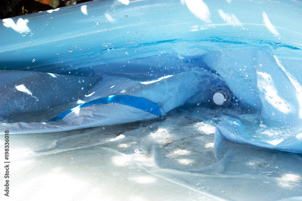 water flows through the valve in the inflatable pool. Blue background ...