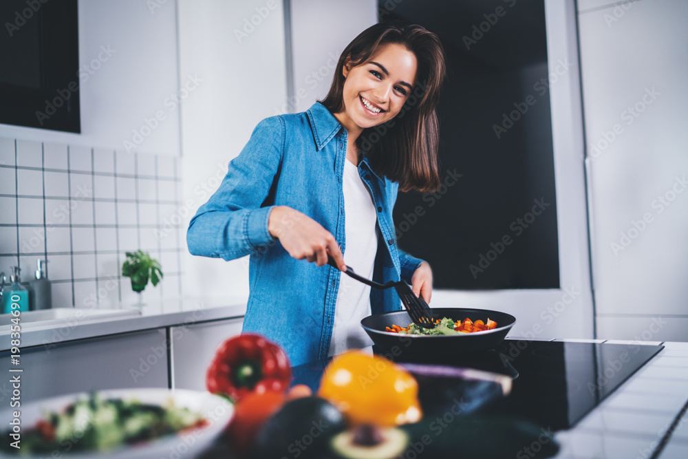 Happy smiling woman cooking in kitchen at home fresh vegetables, happy ...