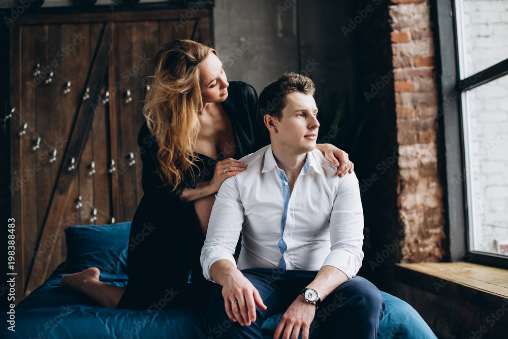 Beautiful young couple on bed in the bedroom. Beautiful blonde girl ...