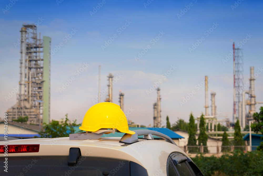Helmet on the roof of car,oil refinery plant,oil tank and oil storage ...