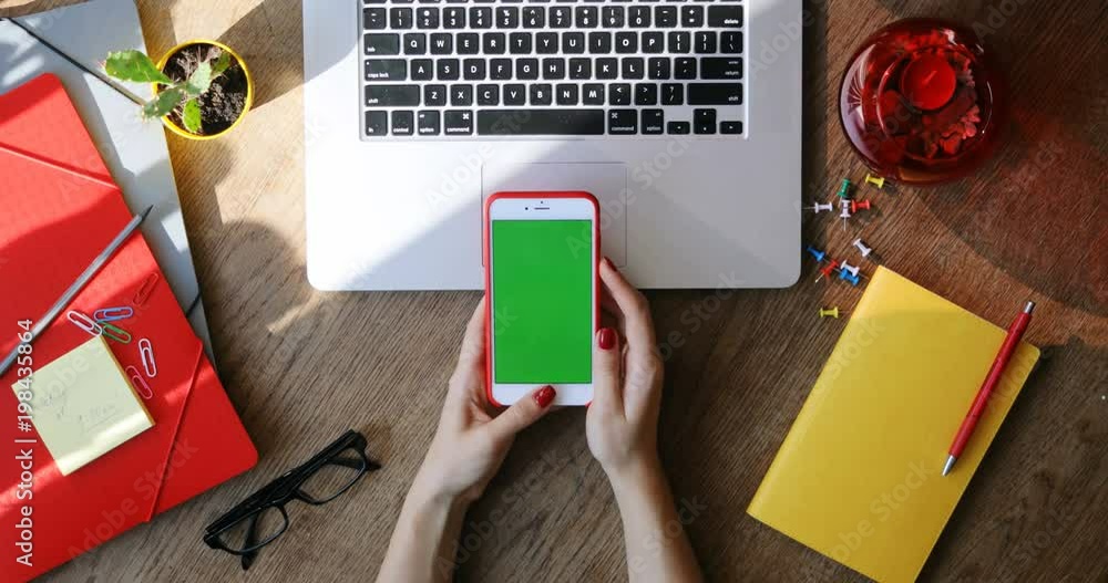 female hands using smartphone mobile with empty green screen top view ...