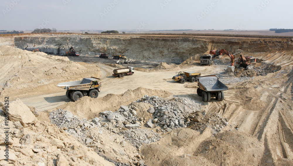 Open Pit Coal Mining - Large Rock Dump Trucks and Excavators digging and hauling in an open pit ...