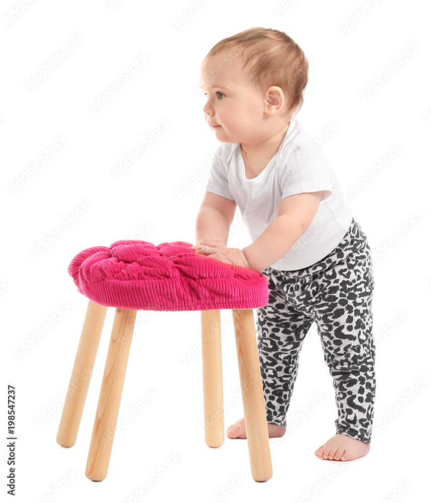 Cute baby holding on to stool on white background. Learning to walk ...