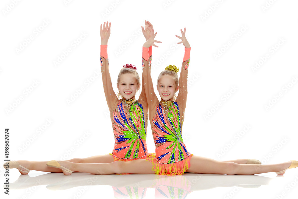 Two girls gymnast sitting on splits. Stock Photo | Adobe Stock