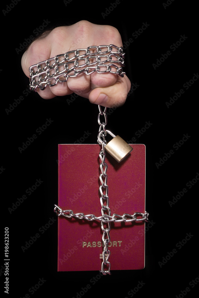 Control over humanity. Passport tied with a chain, on a black ...