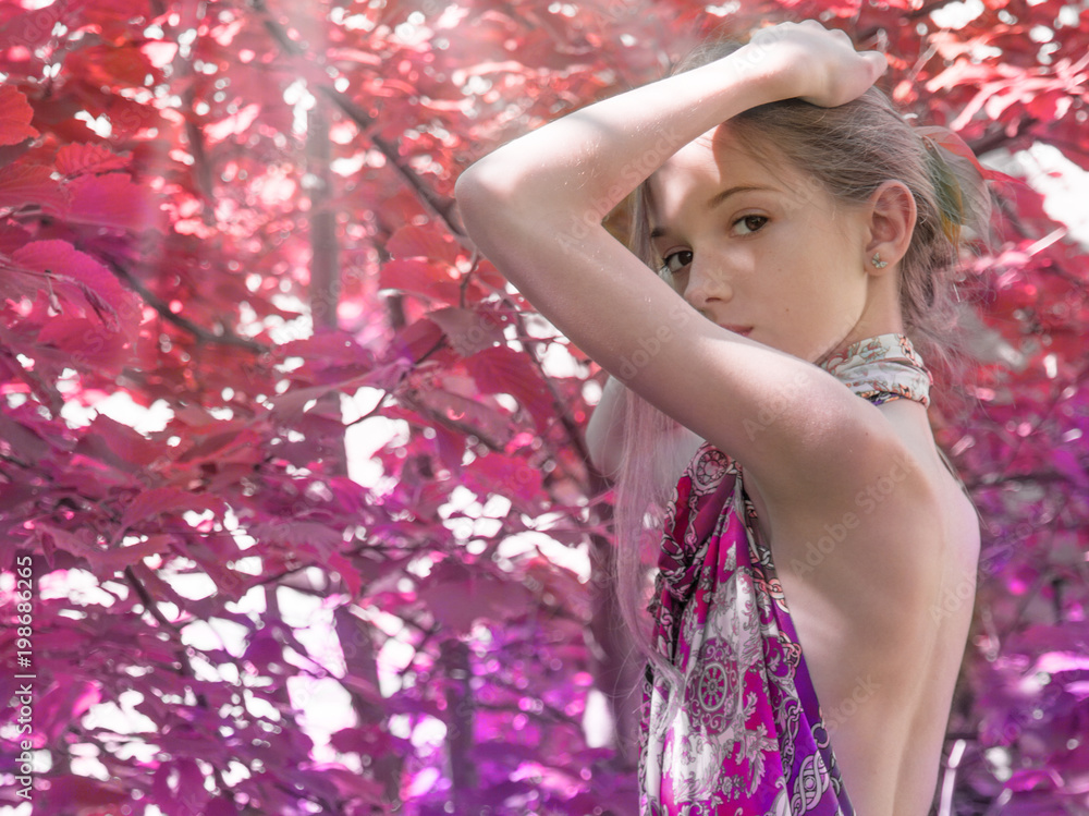 A Young Girl In A Dress With Nude Backs Worth In The Foliage In The