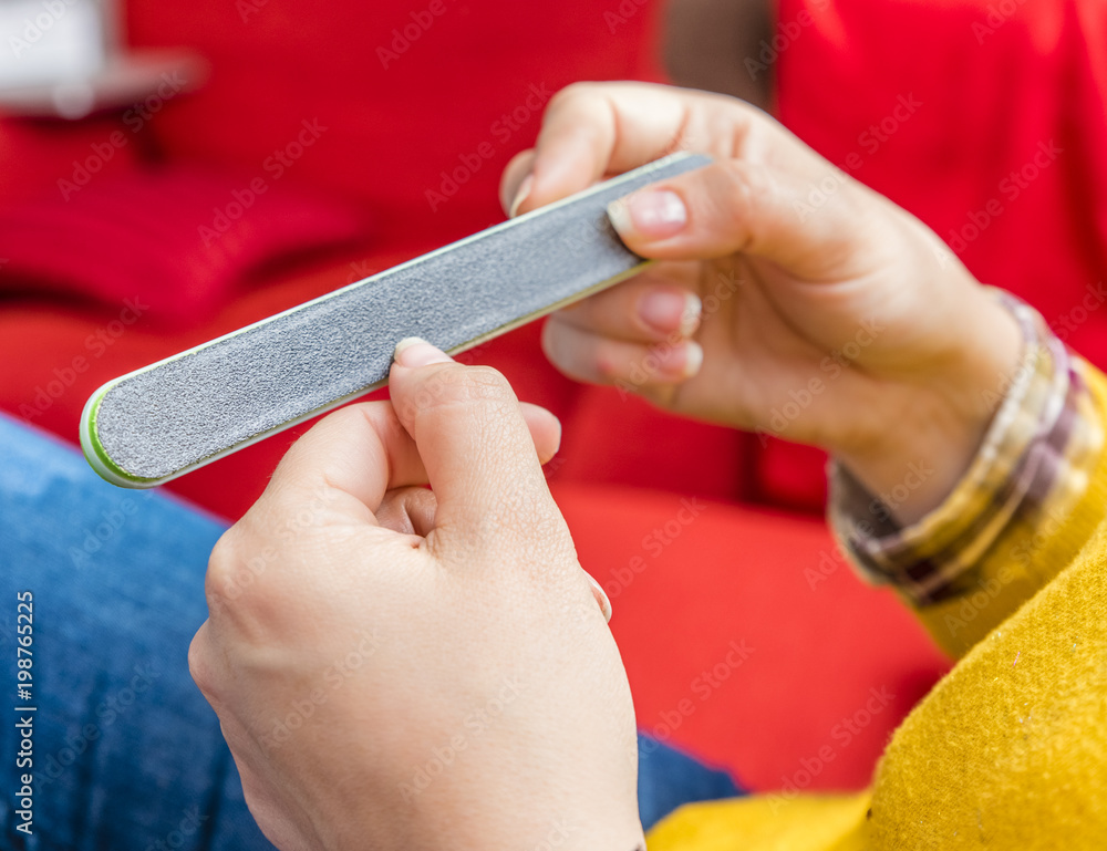 woman filing her nails Stock Photo | Adobe Stock