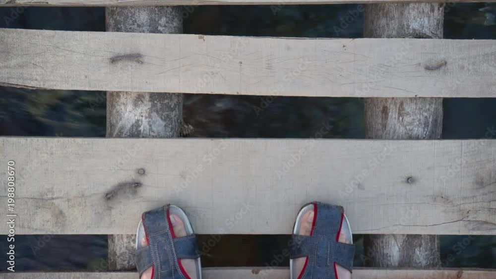 water flowing under a bridge of wooden plans. The water flow is visible ...