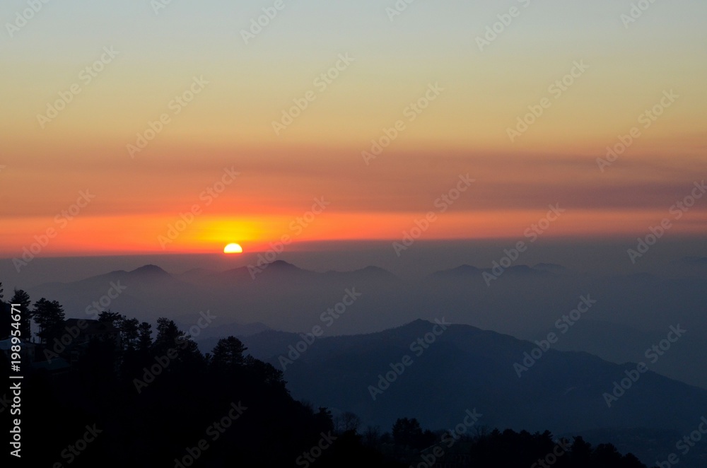 Murree, Pakistan - January 15, 2018: Sunset over pine trees and hills ...