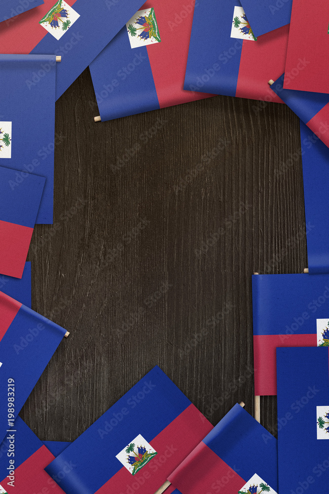 Haiti small flags framing a wood texture background with copy space ...