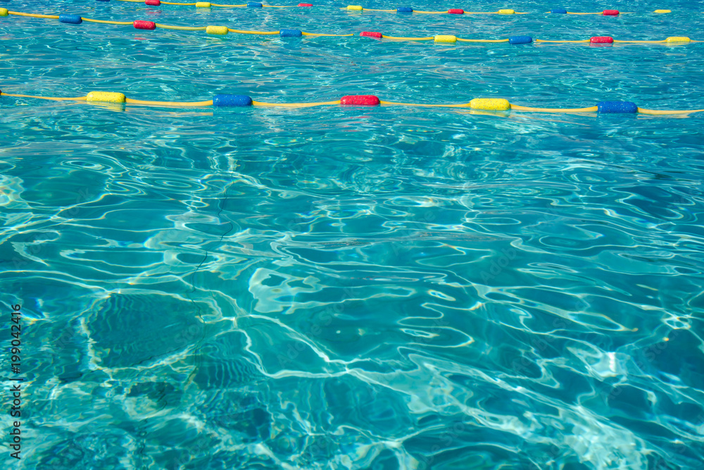 Light and shade ripples pattern in a swimming pool with turquoise clean ...