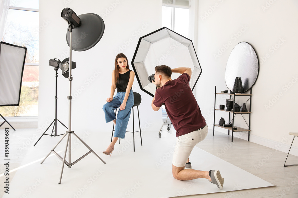 Beautiful young model posing for professional photographer in studio ...