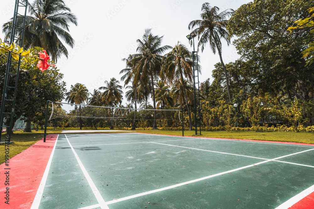 Side wide-angle view of the badminton court on a summer day: red and ...