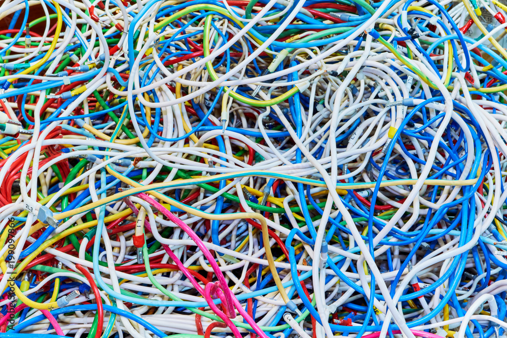The bunch of electric wires or cables are strongly tangled together ...