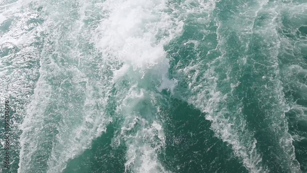 Sea waves from a boat a huge stream of deep blue water with white foam ...