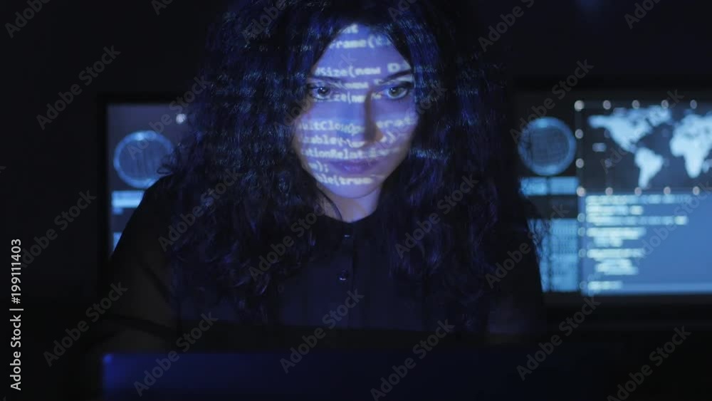 Woman Hacker programmer with curly hair is working on computer in cyber security center filled ...