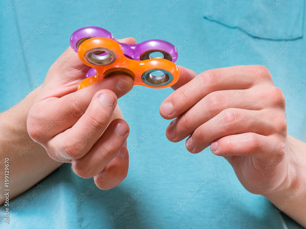 Male child hand holding popular fidget spinner toys - close up. Boy ...