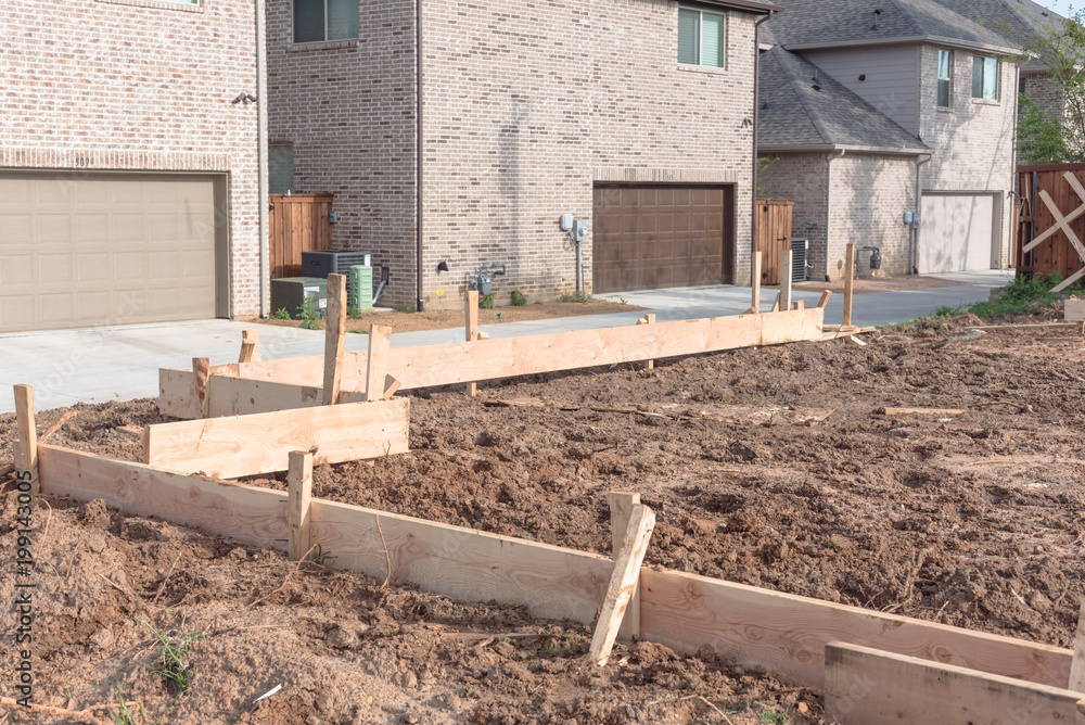 Wooden formwork concrete strip foundation for new house near completed ...