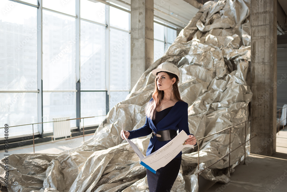 Beautiful girl engineer in construction white helmet at construction ...