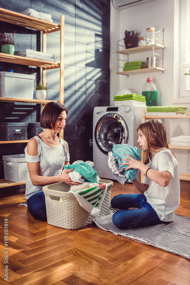 Mother and daughter talking and sorting laundry on the floor Stock ...