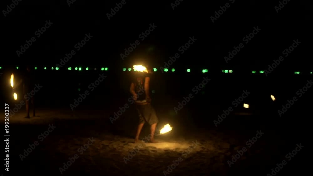 Few fire artists perform fire stunts on a beach in slow motion Light ...