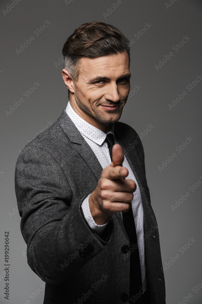 Portrait of joyful business man wearing business suit posing on camera ...