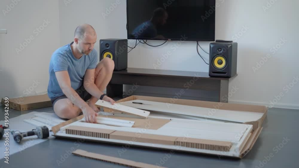 Handyman bought a new table for his home and unpacking it on the floor ...