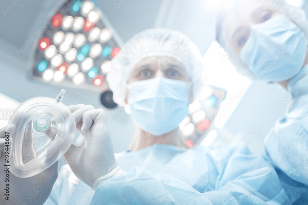 General anaesthesia. Nice professional smart surgeon holding a medical ...